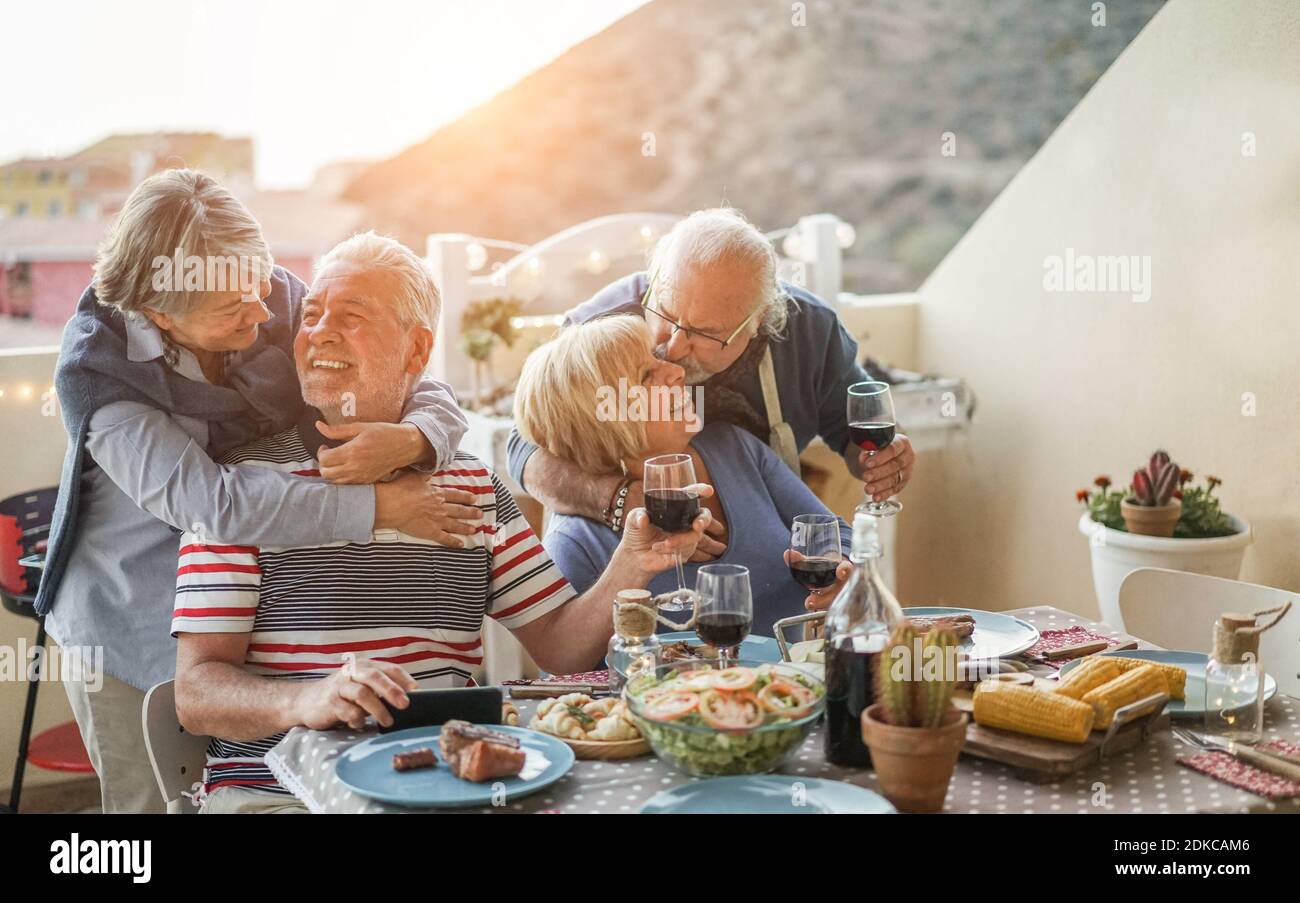 Happy People Having Food At Table In Balcony Stock Photo - Alamy