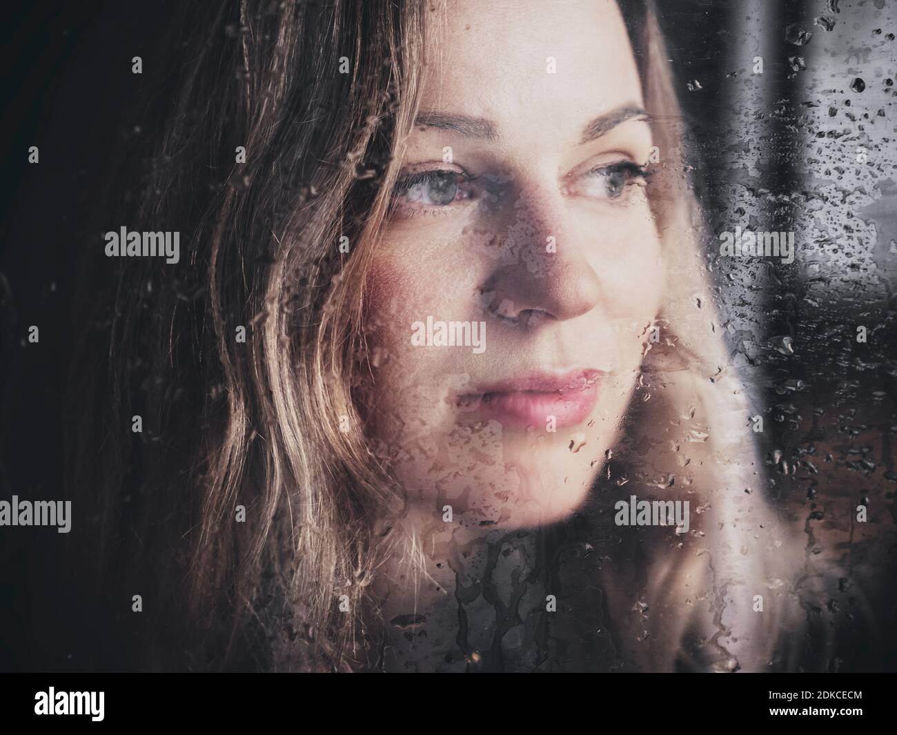 Beautiful woman behind wet window Stock Photo - Alamy