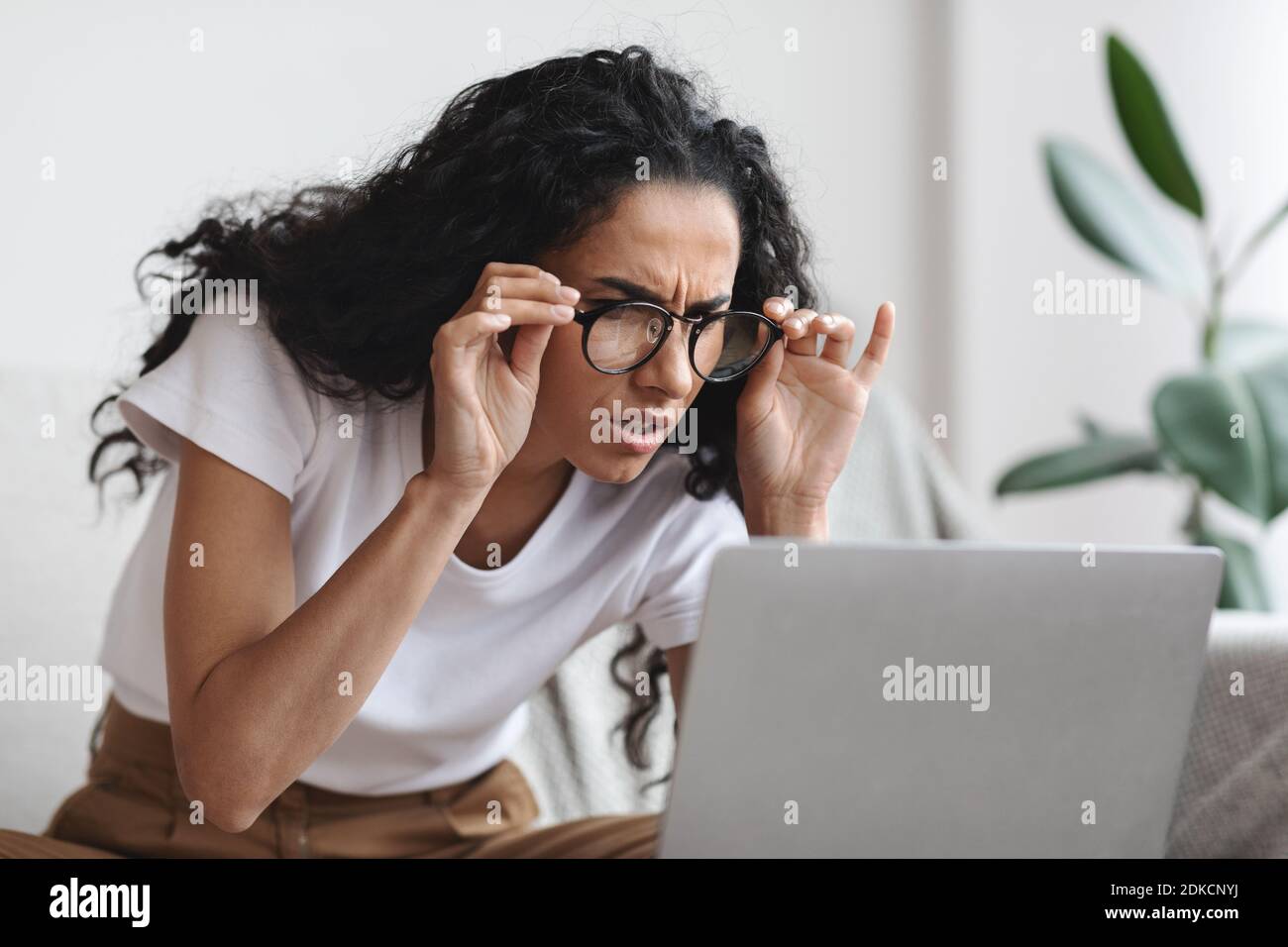 Young woman with bad eyesight using laptop, wearing glasses Stock Photo ...