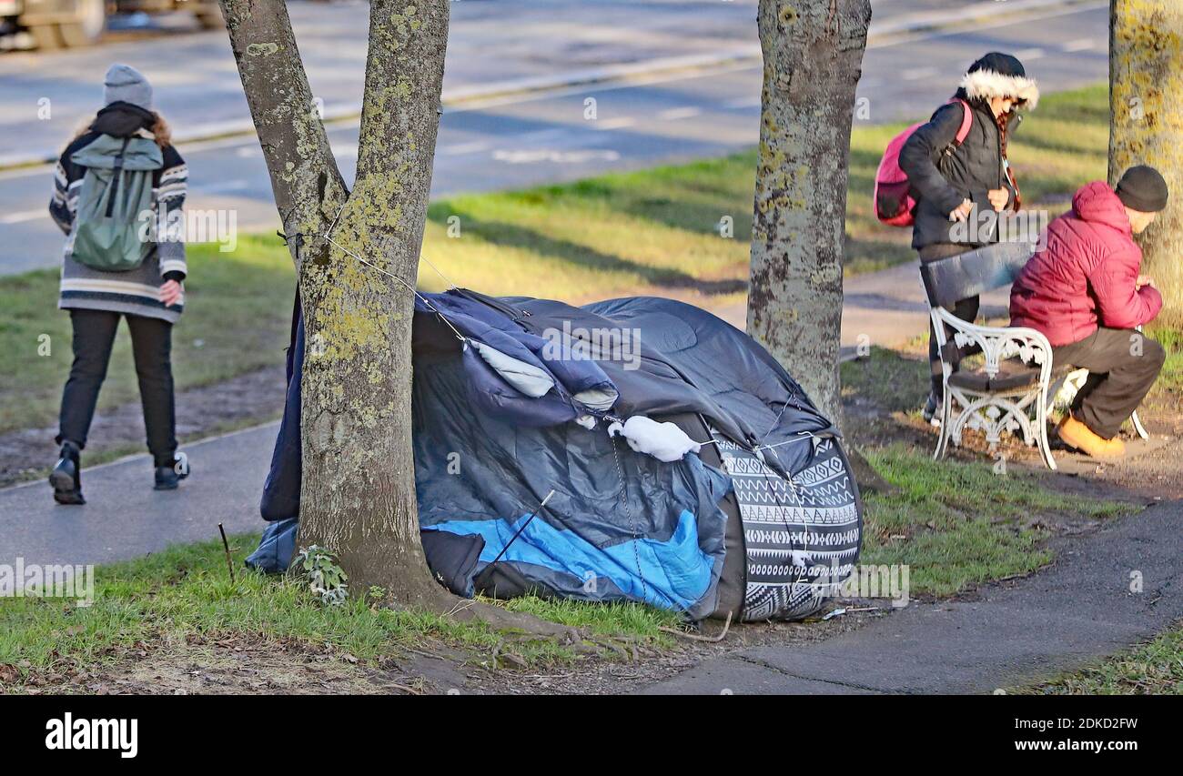 People walk past the tents of homeless people near Dublin's Grand Canal ...
