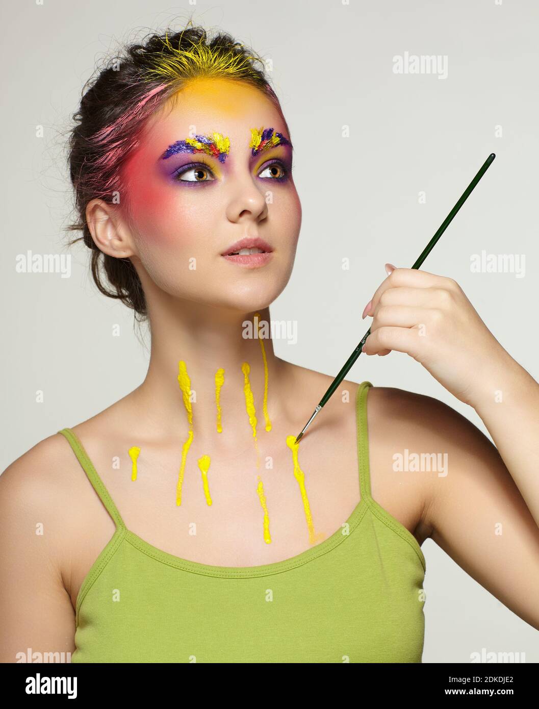 Female portrait with unusual face and body art make-up. Paint on brows ...