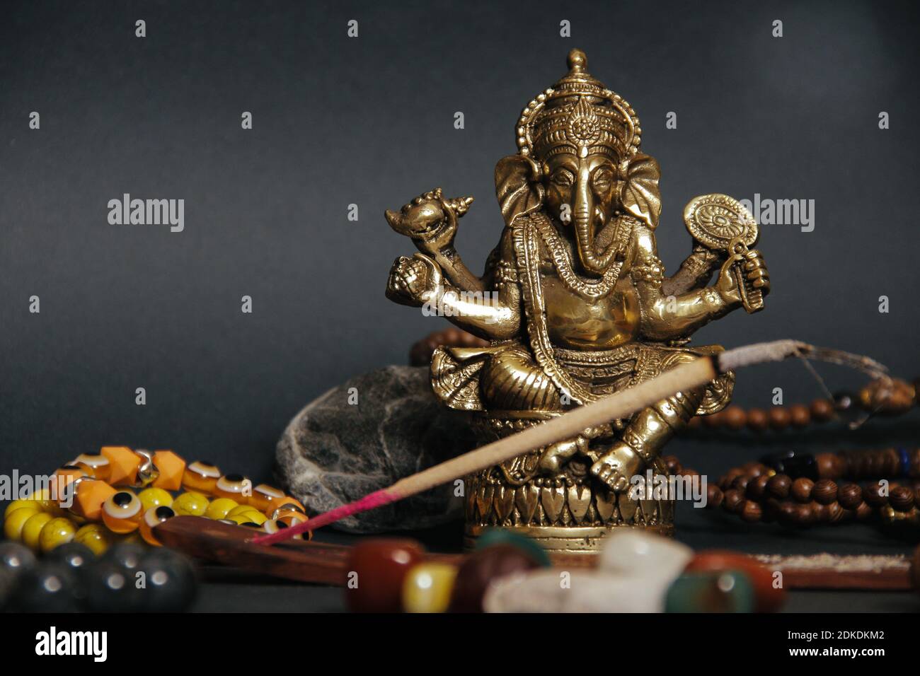 Occult altar with figurine of god Ganesha, candles, aroma stick, stones ...