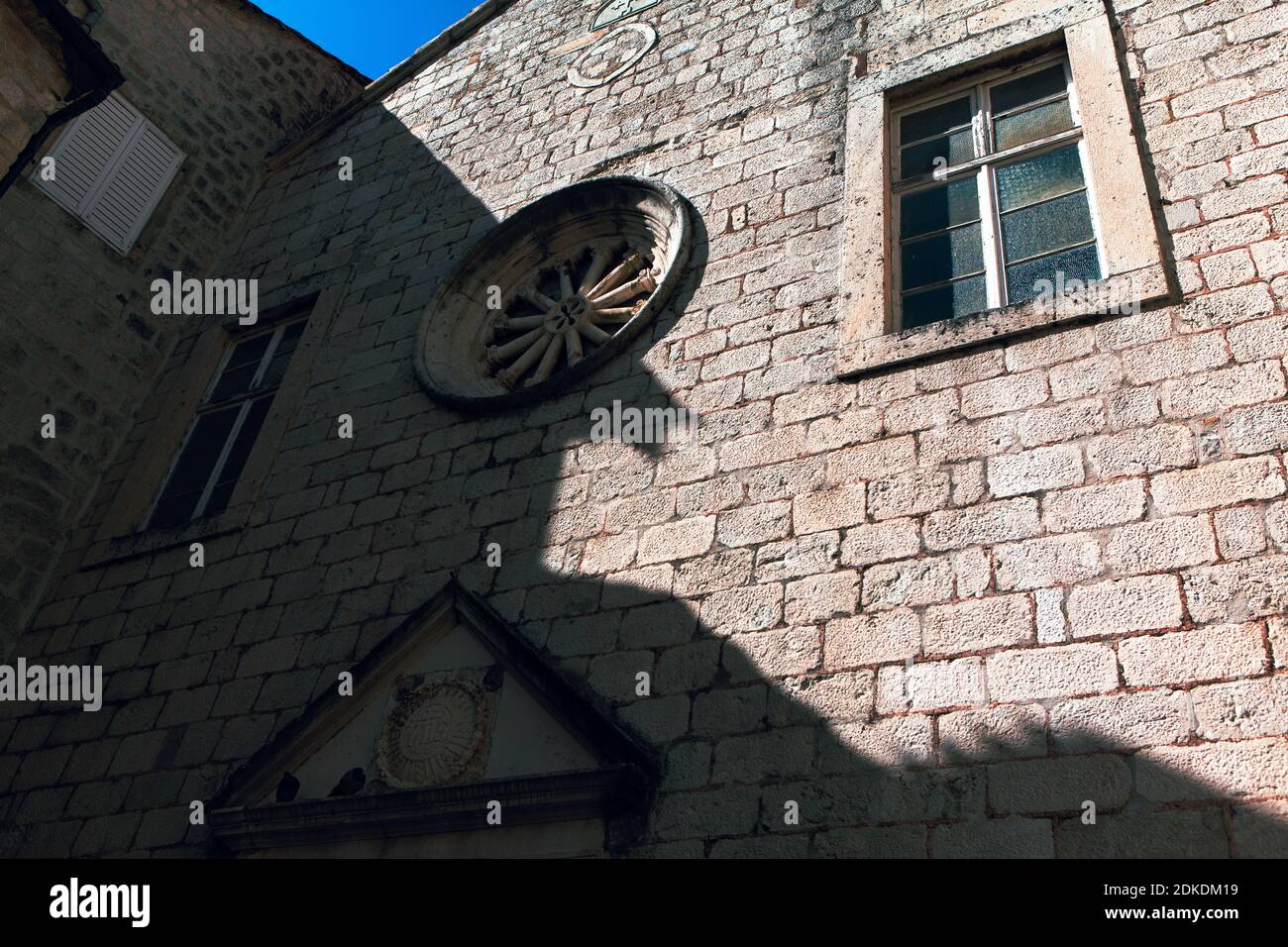 Church side view with Rose Window . Bricks wall with shadow Stock Photo ...