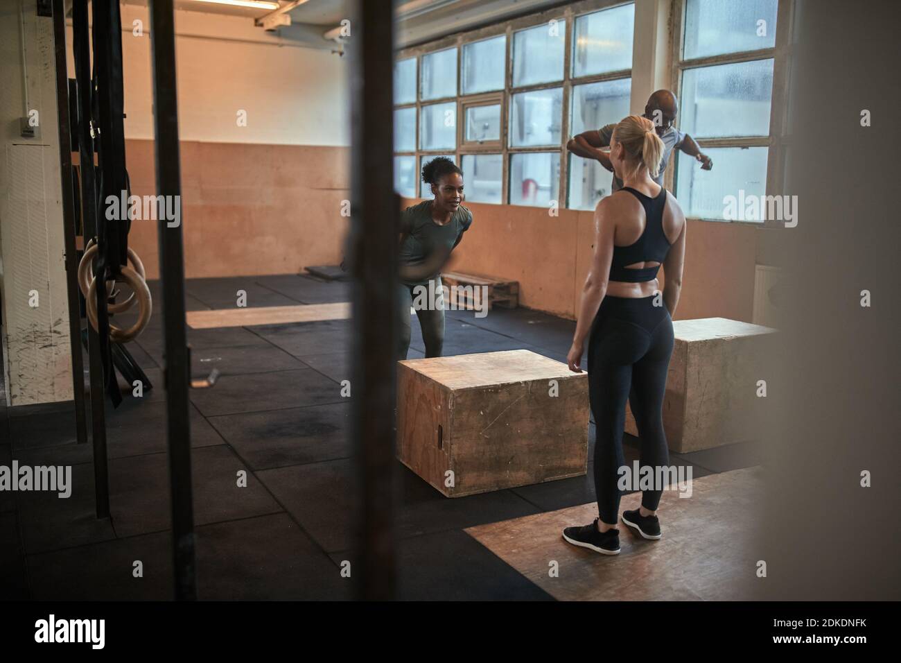 Fit group of diverse young people doing box jumps during an exercise ...
