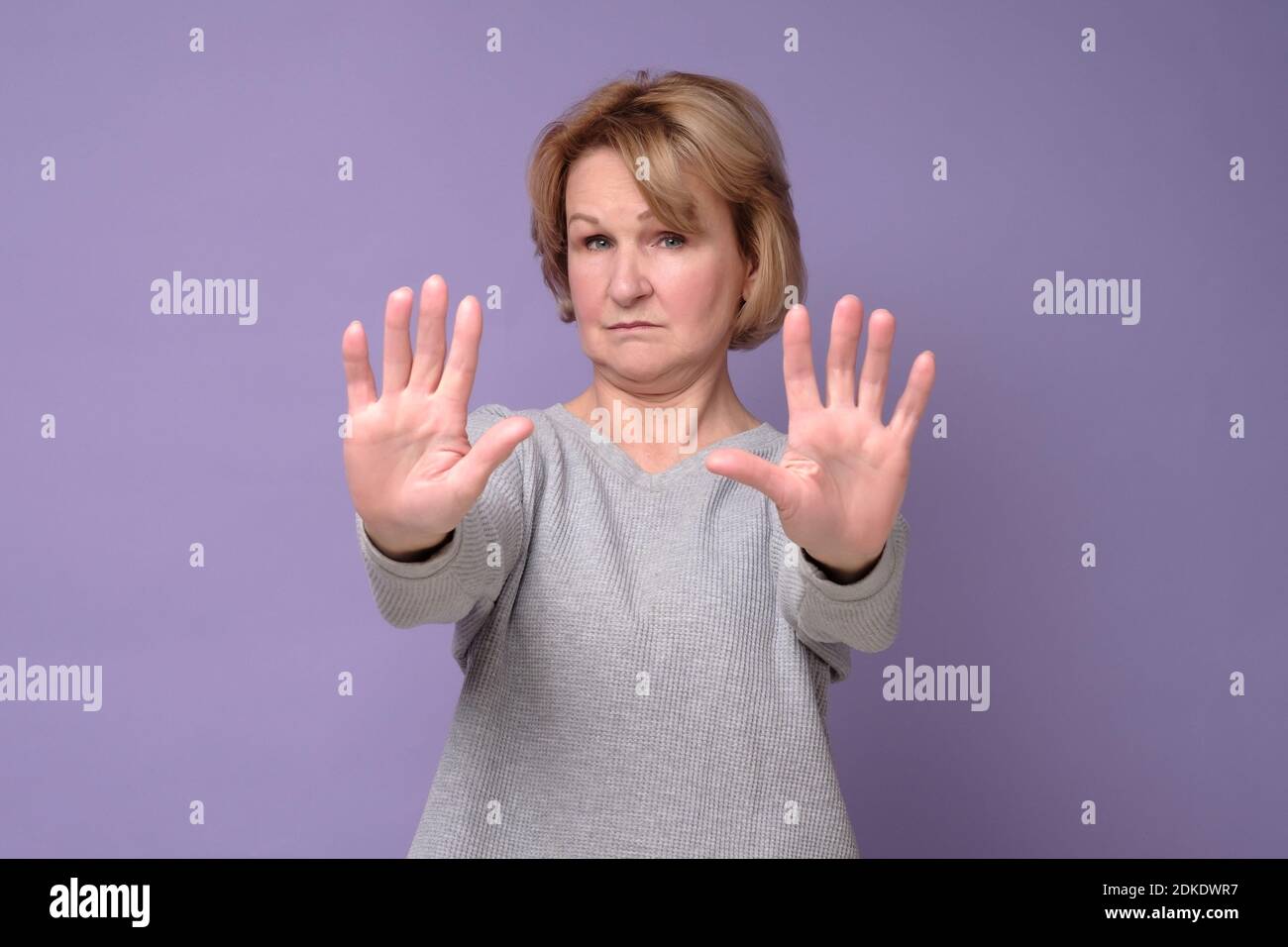 Middle age woman doing stop sing with palm of the hand. Warning ...