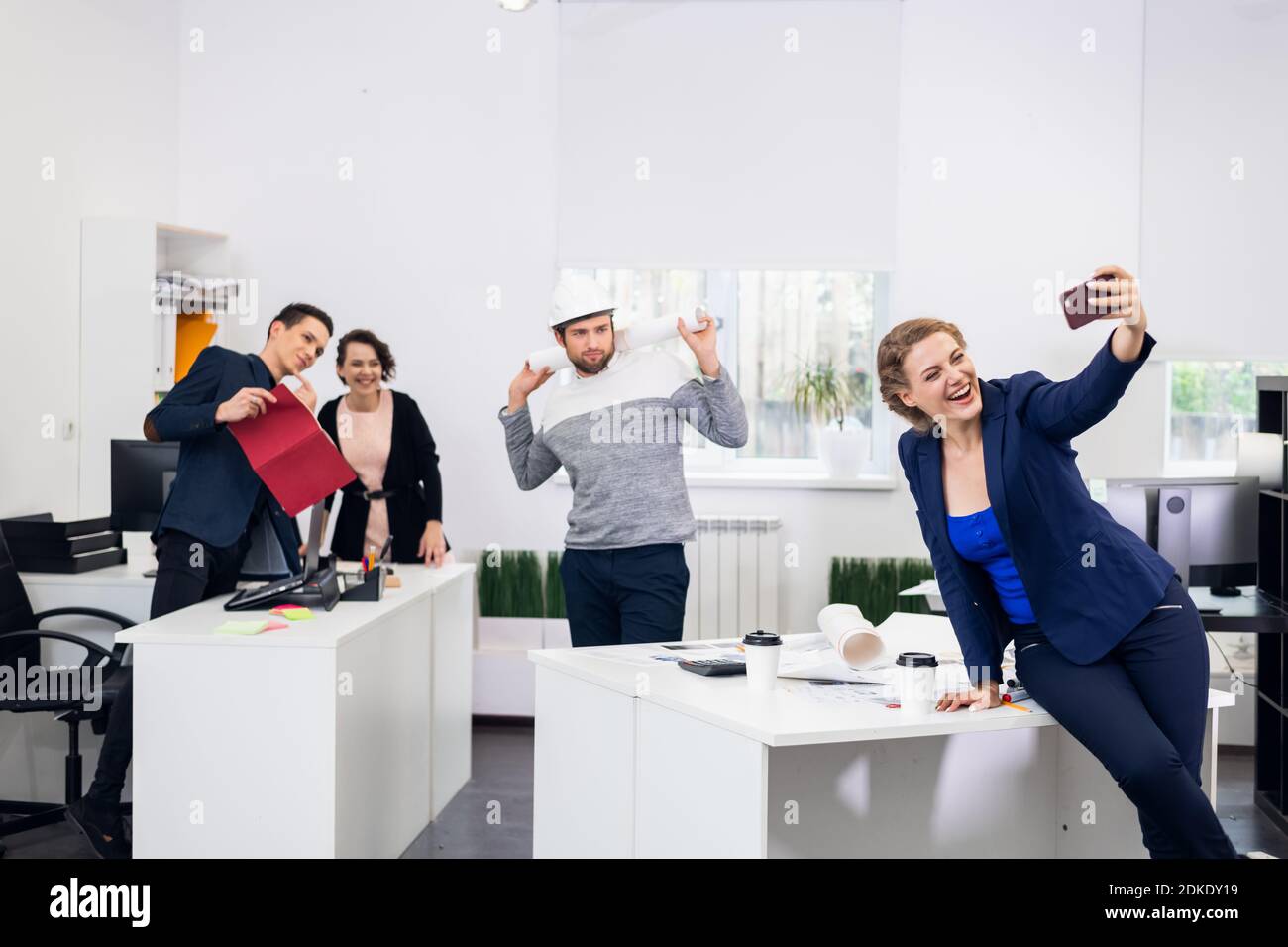 Happy young colleagues smile, have fun and take selfies at the creative ...