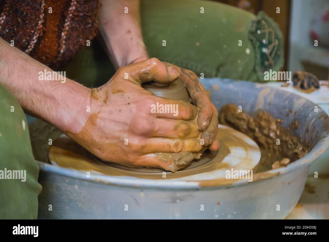 Close up view - professional male potter making pot in pottery workshop ...