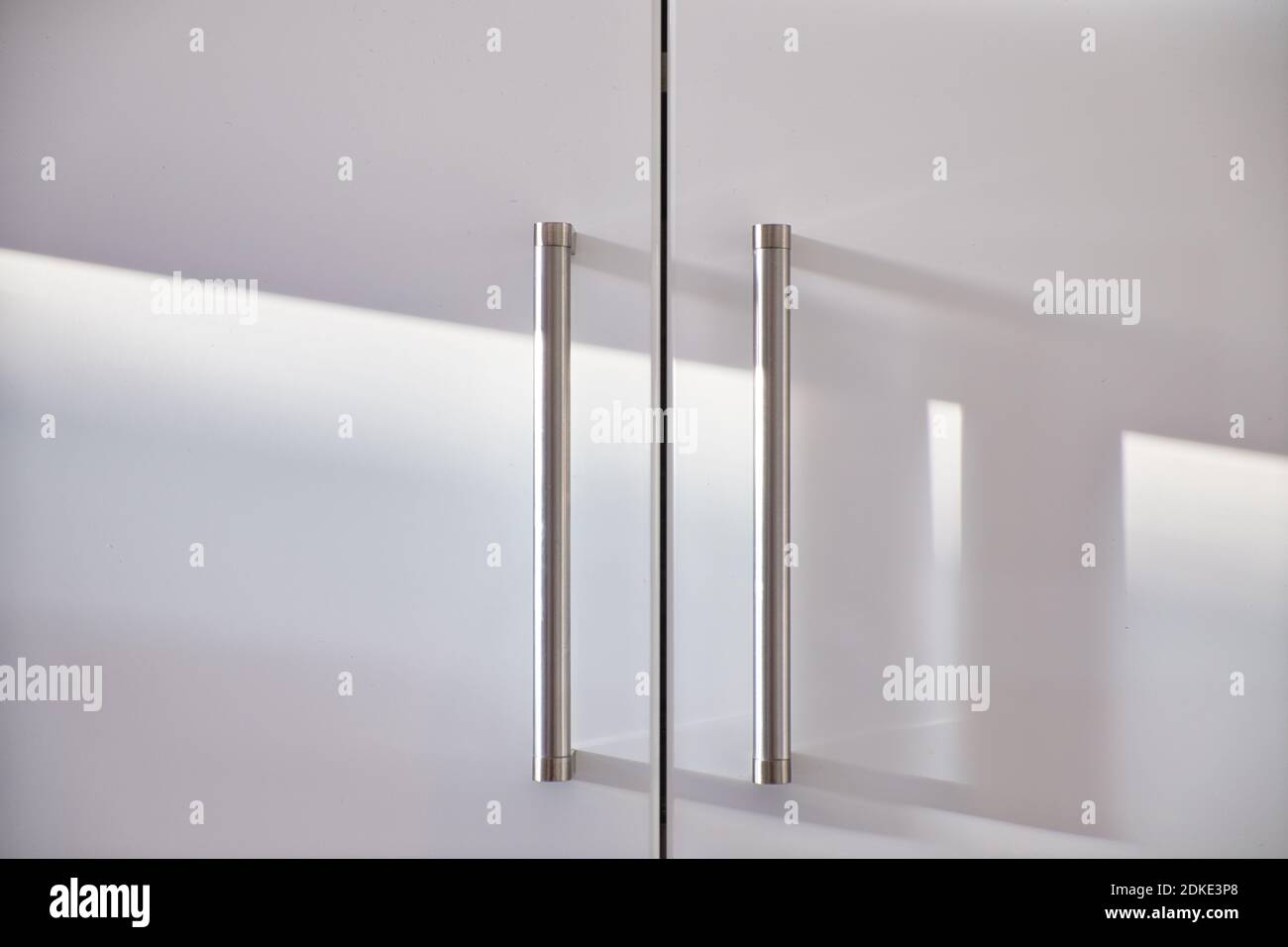Modern wooden closet with metal door handles and day shadows Stock ...