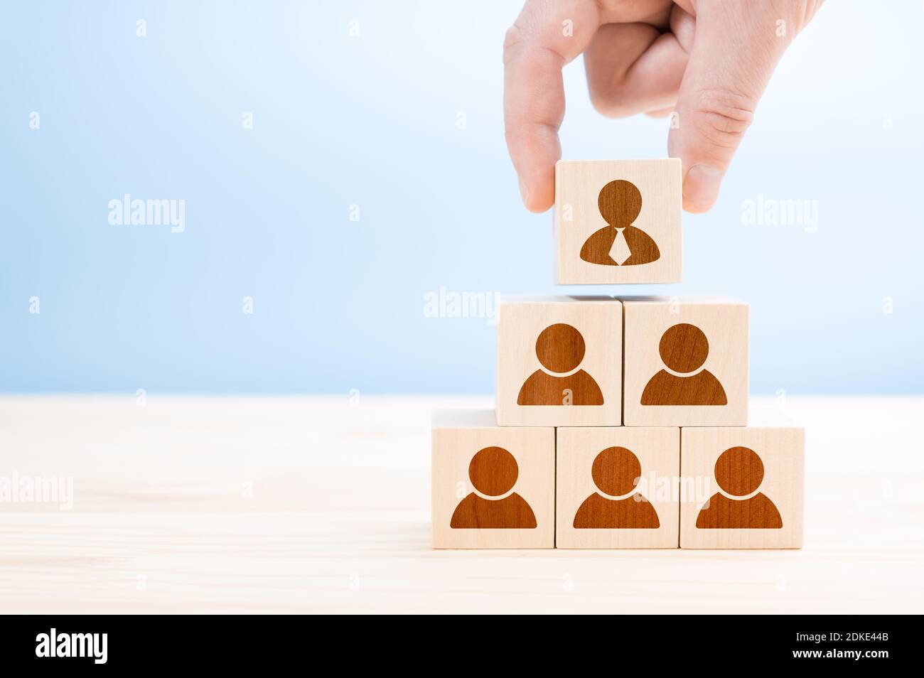 Management hierarchy pyramid with wooden cubes on blue. Human resources ...