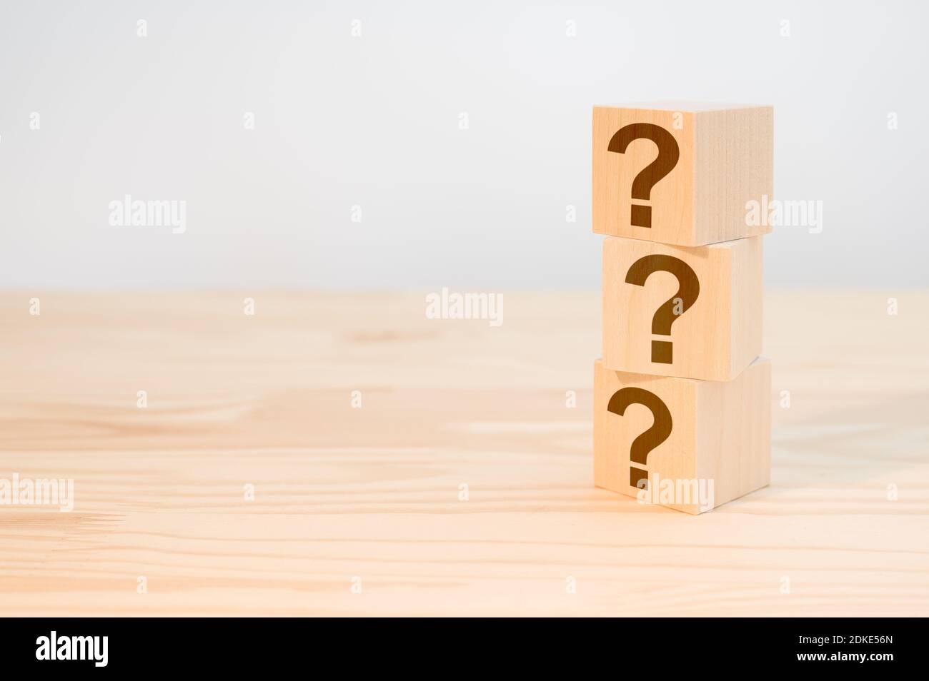 Wooden cube block shape with sign question mark symbol on wood table ...