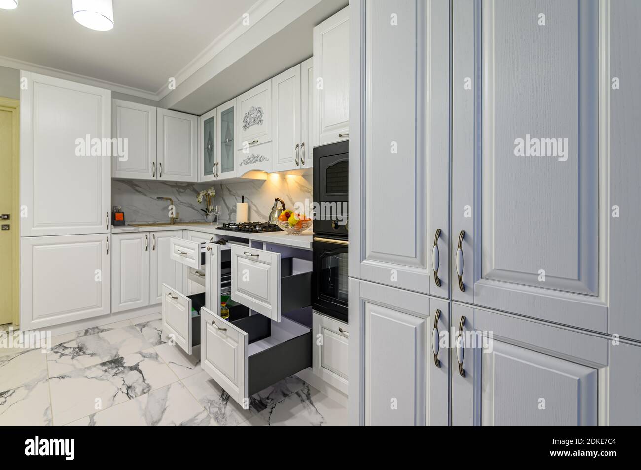 Open drawers with kitchenware at modern white kitchen Stock Photo - Alamy