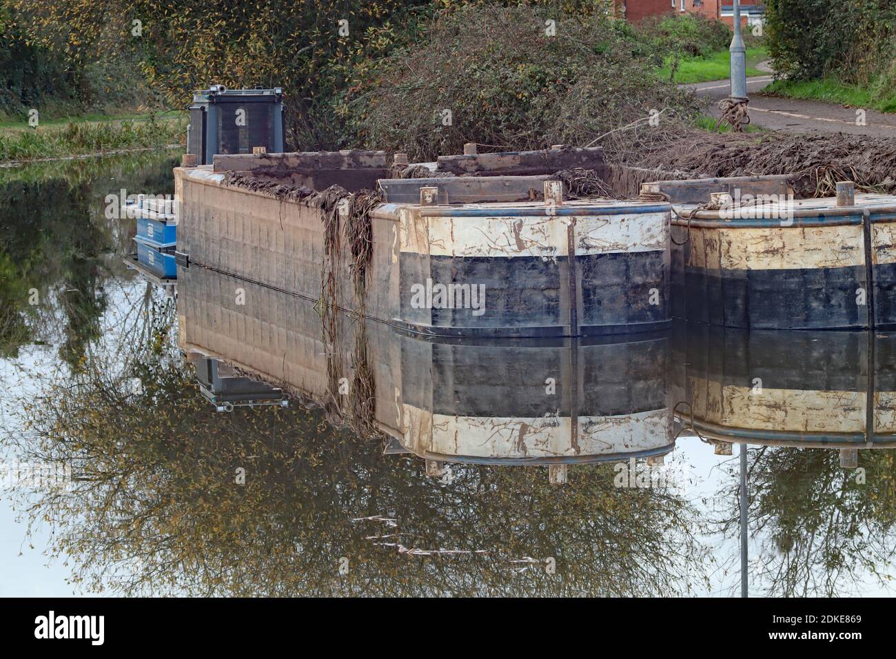 Two barges moored on a murky canal in England, filled with mud from a ...