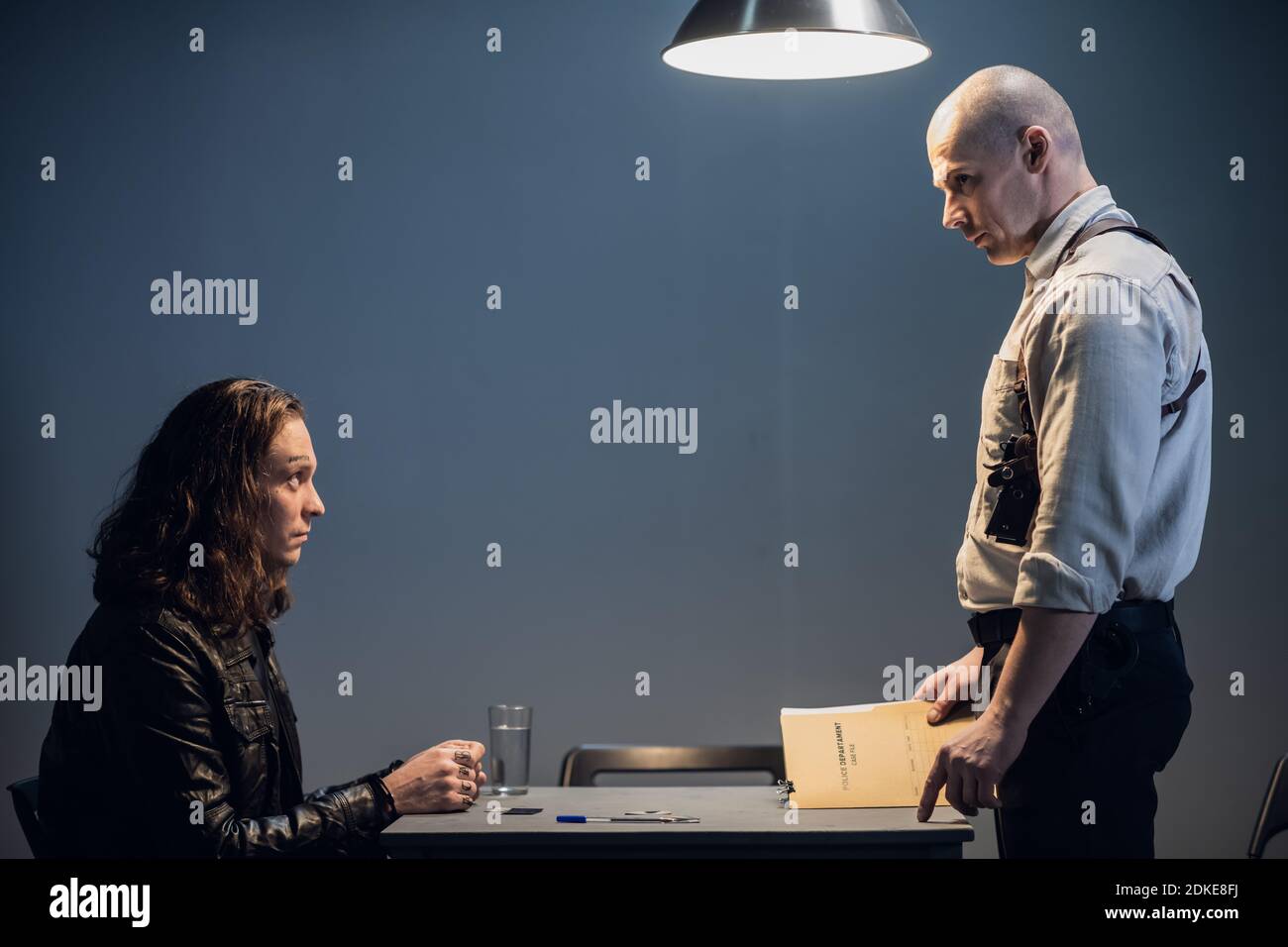 A young detective interviews a suspect in a crime Stock Photo - Alamy