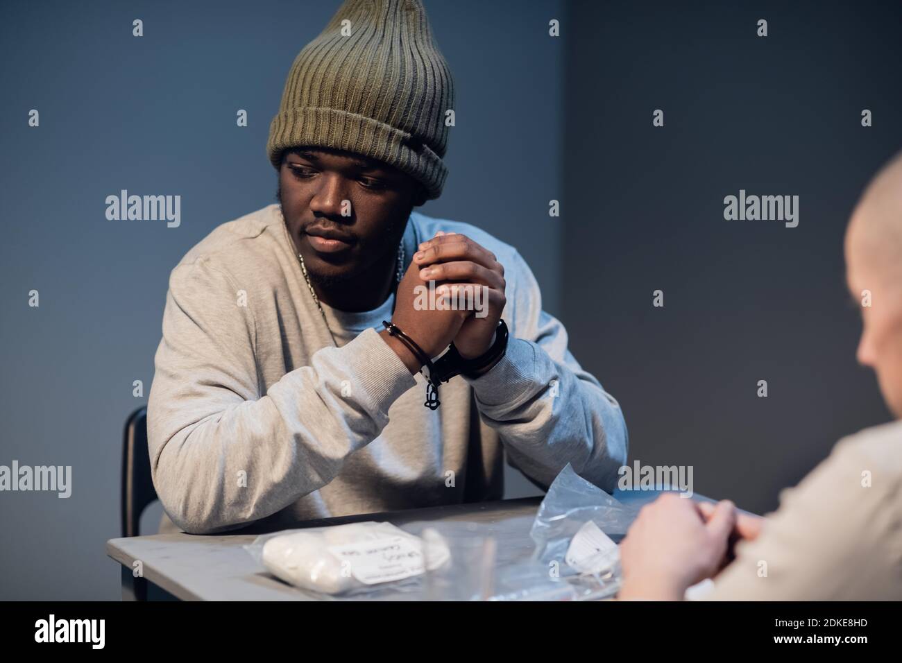 Black accused guy in police station for questioning with a bag of white ...