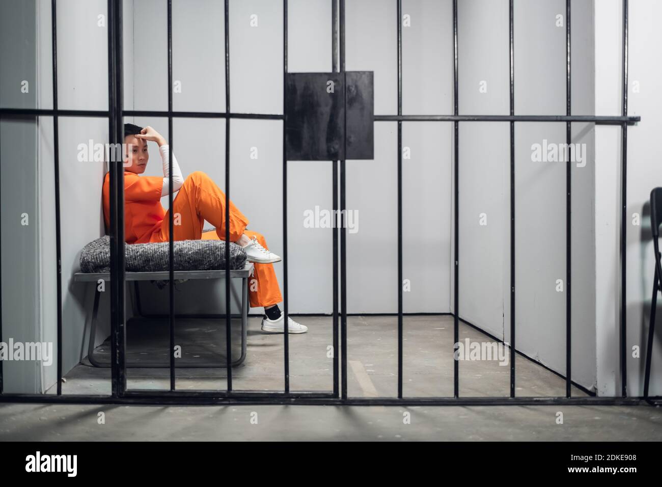 A sad depressed prisoner is serving a long time in prison in solitary ...