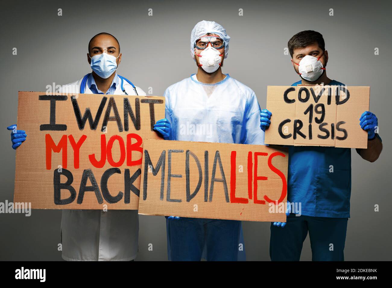 People in medical gowns wearing face masks protesting and holding ...