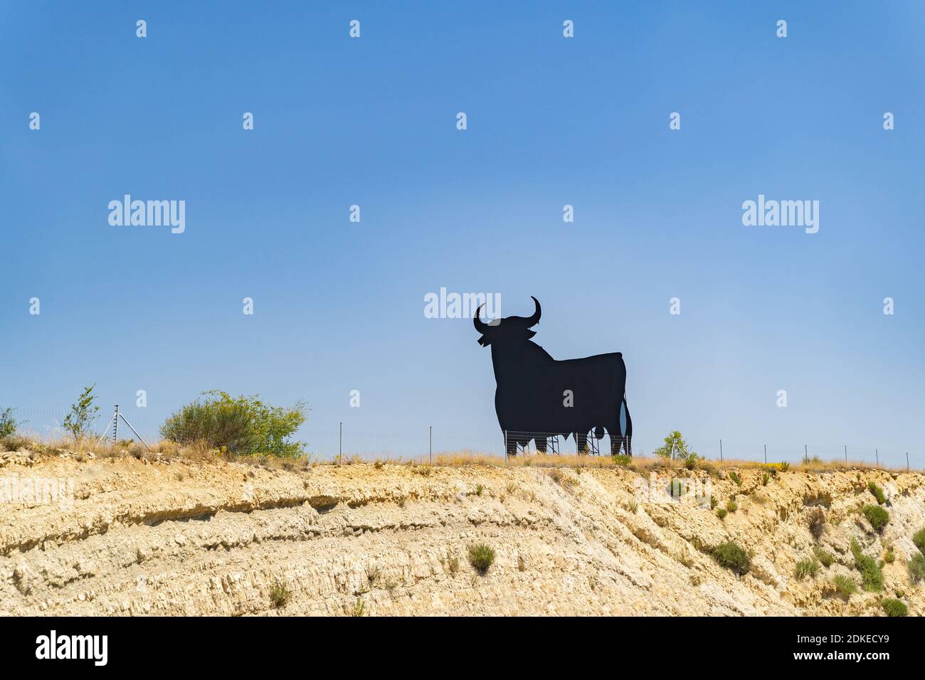 Sign of a black spanish bull in desert with blue sky and bushes on a ...