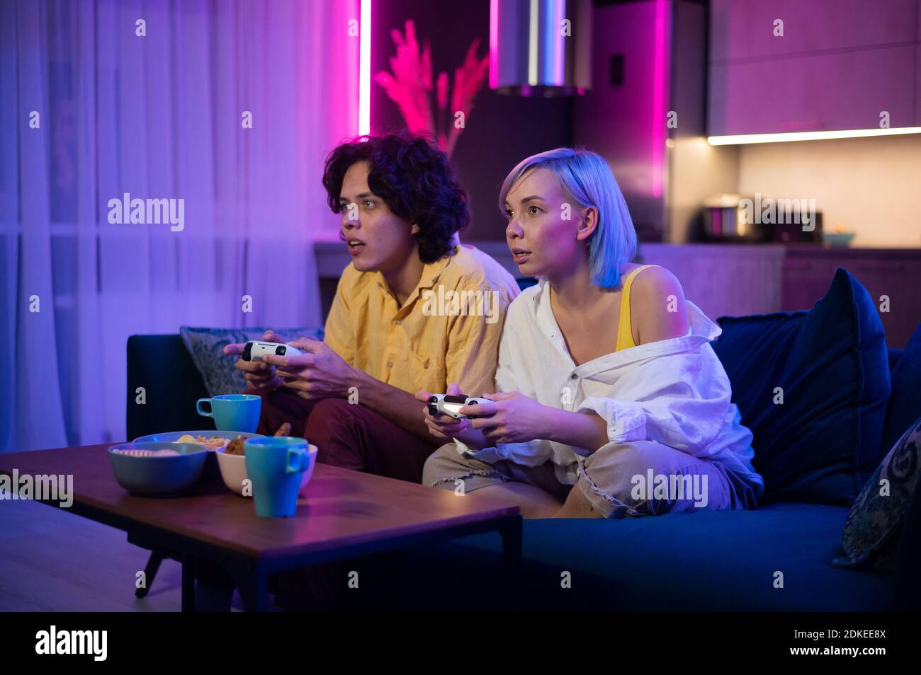 Happy boyfriend and girlfriend playing video games and holding ...