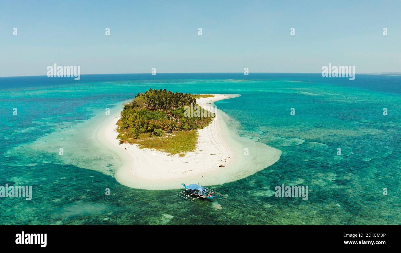 Small tropical island in the blue sea with a coral reef and the beach ...