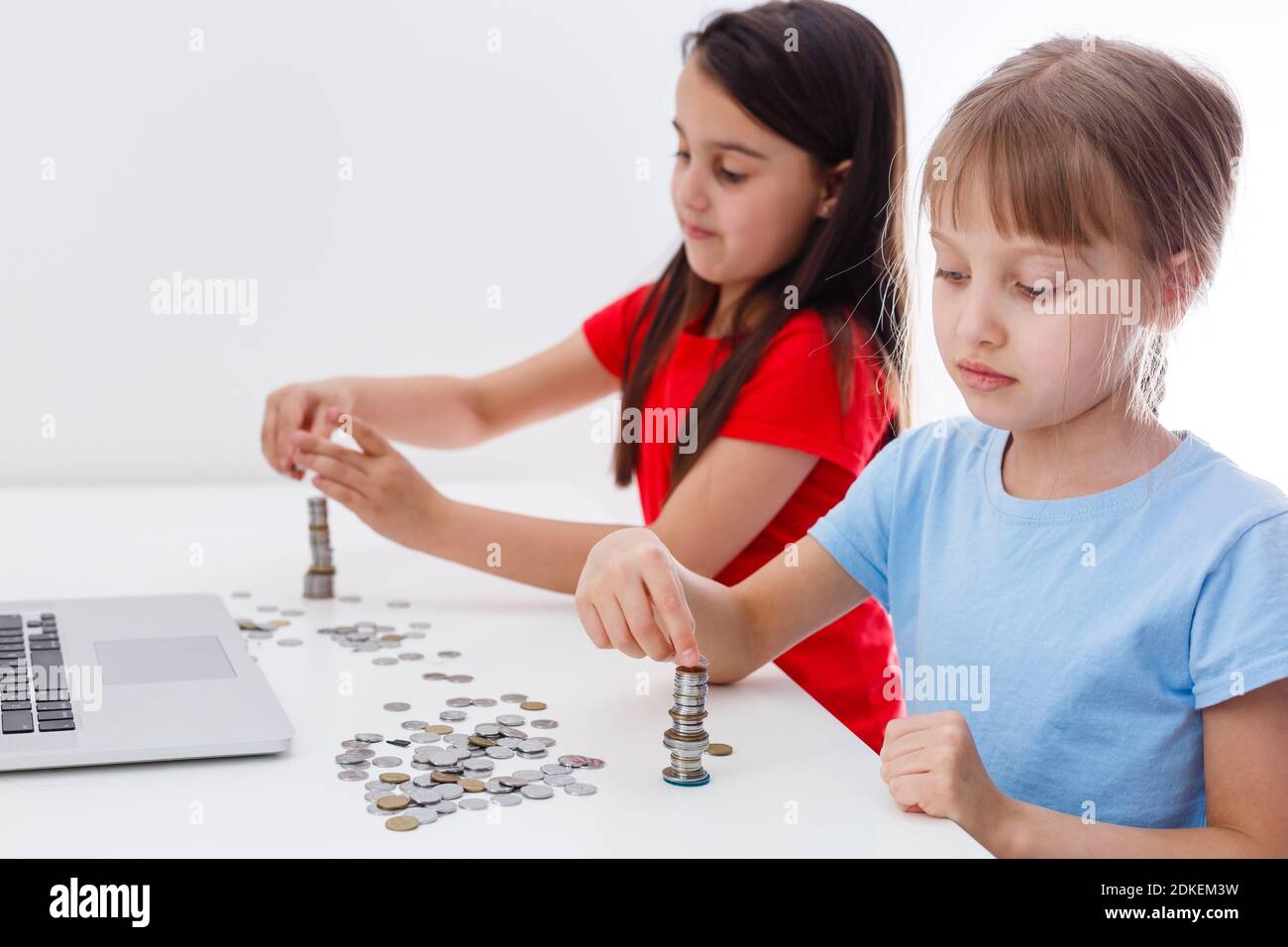 portrait of little girls sitting at table and calculating money Stock ...