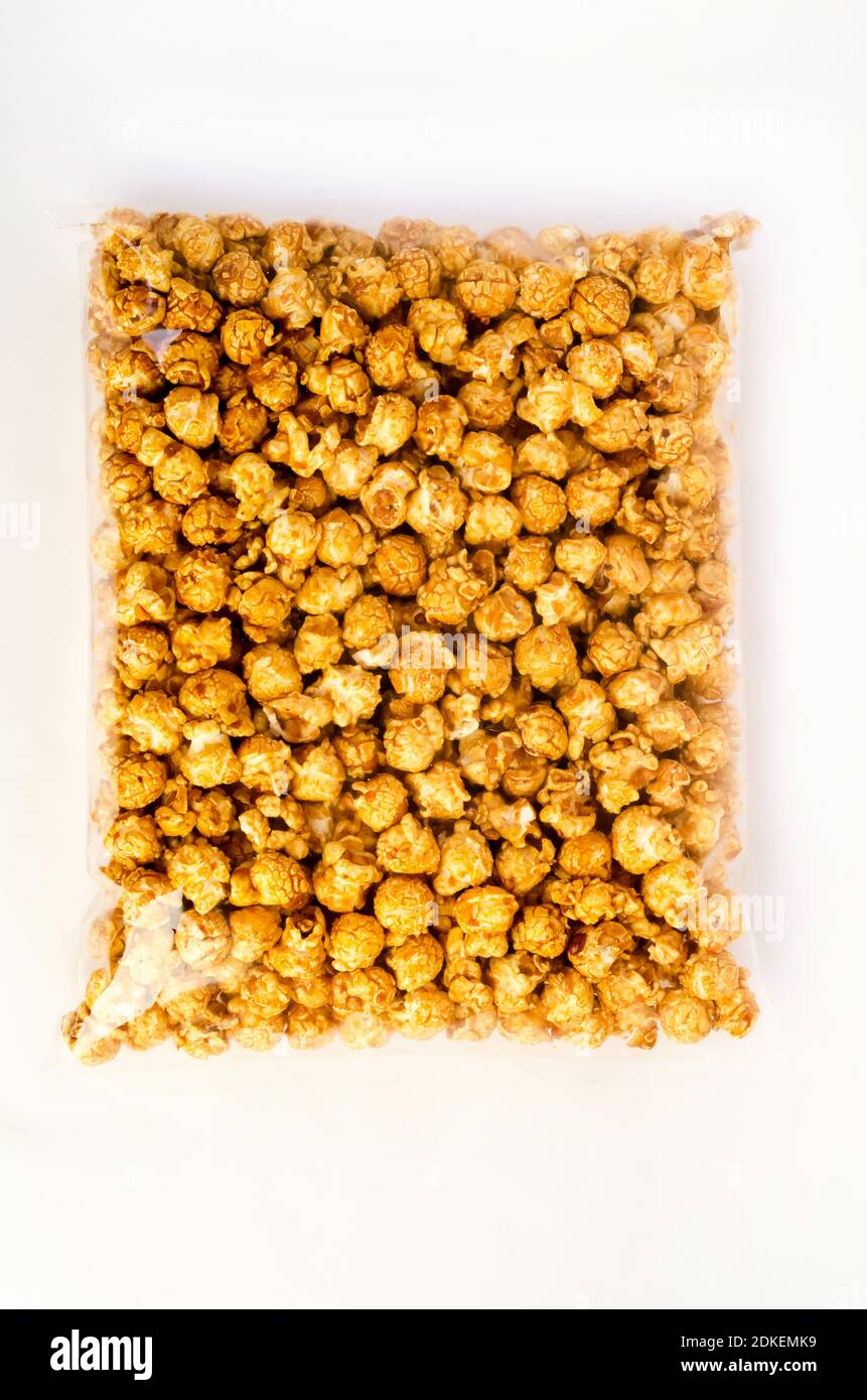Caramel yellow popcorn in a package on a white background close up ...