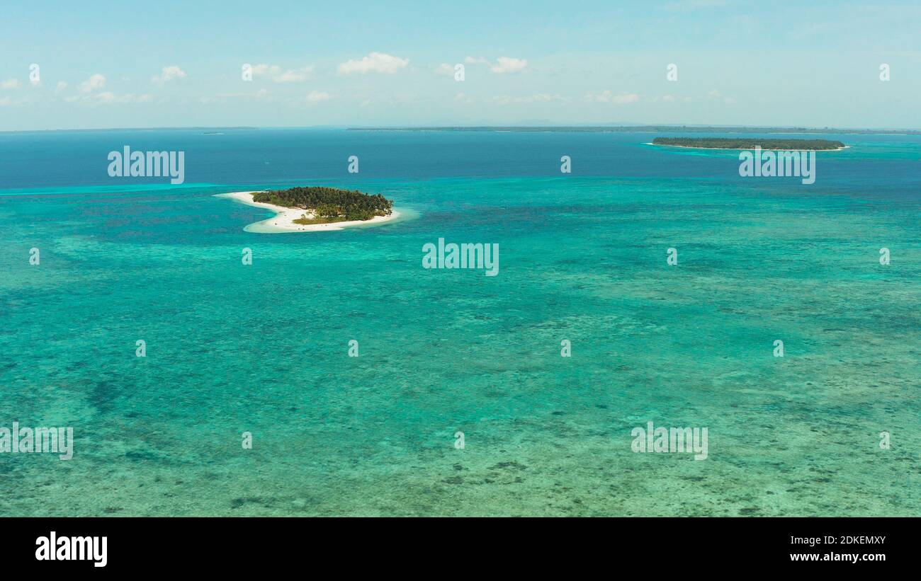 Small tropical island in the blue sea with a coral reef and the beach ...