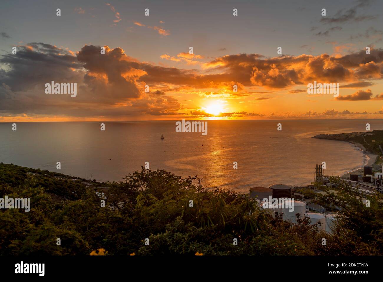 Scenic yellow sun setting over the caribbean sea Stock Photo - Alamy