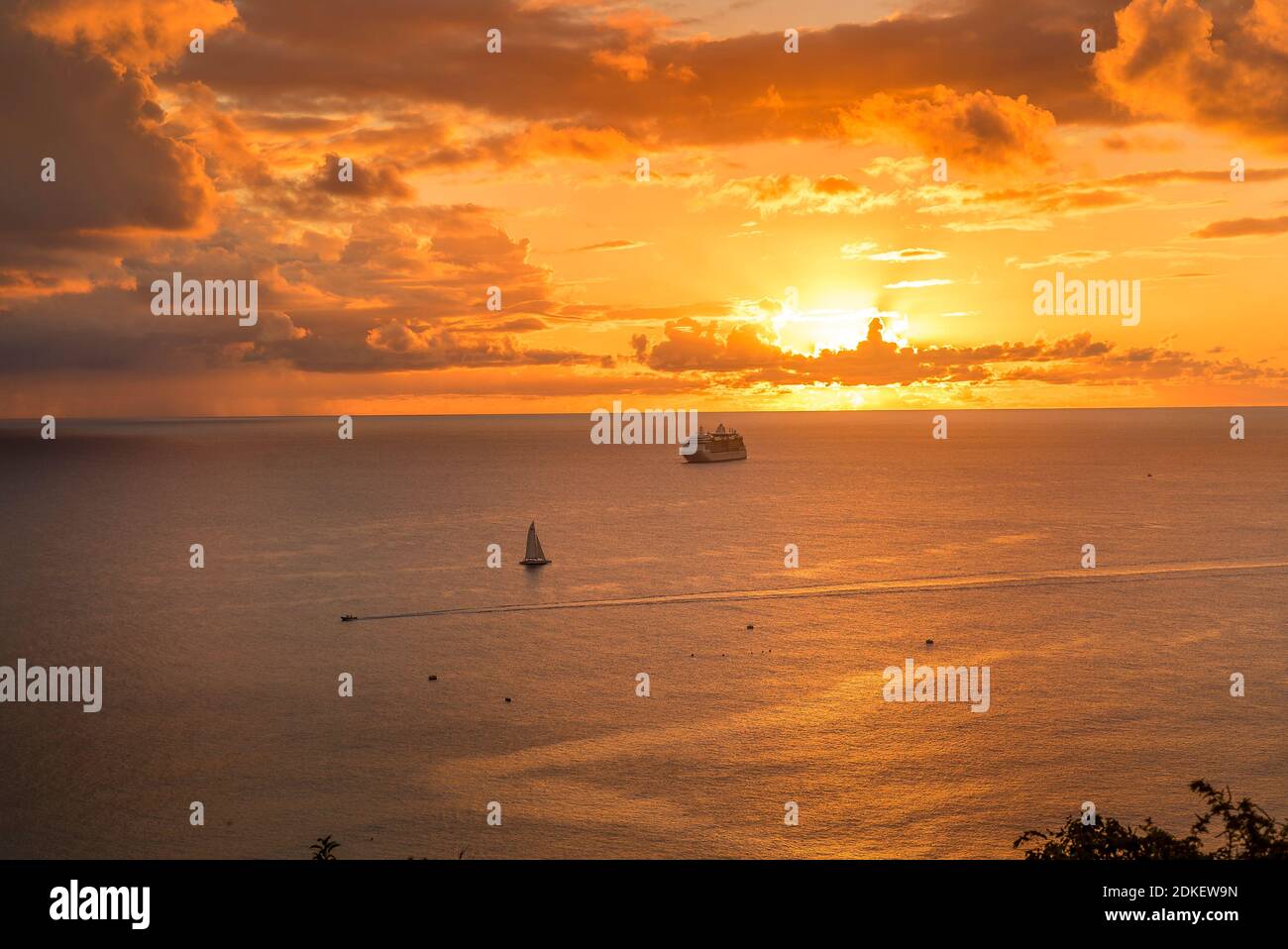 Scenic yellow sun setting over the caribbean sea Stock Photo - Alamy