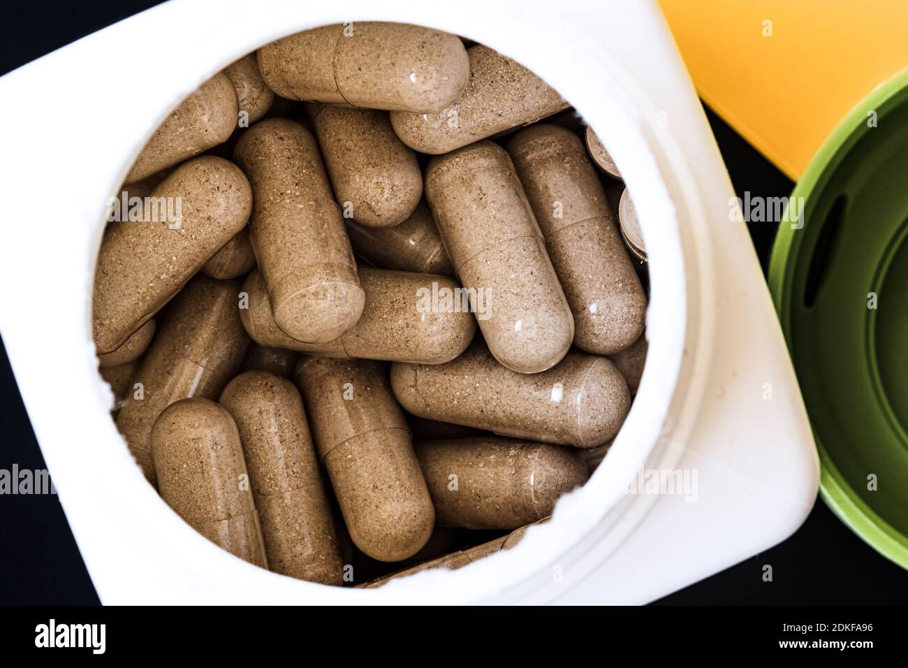close-up of slippery elm capsules in a white jar. dietary concept ...