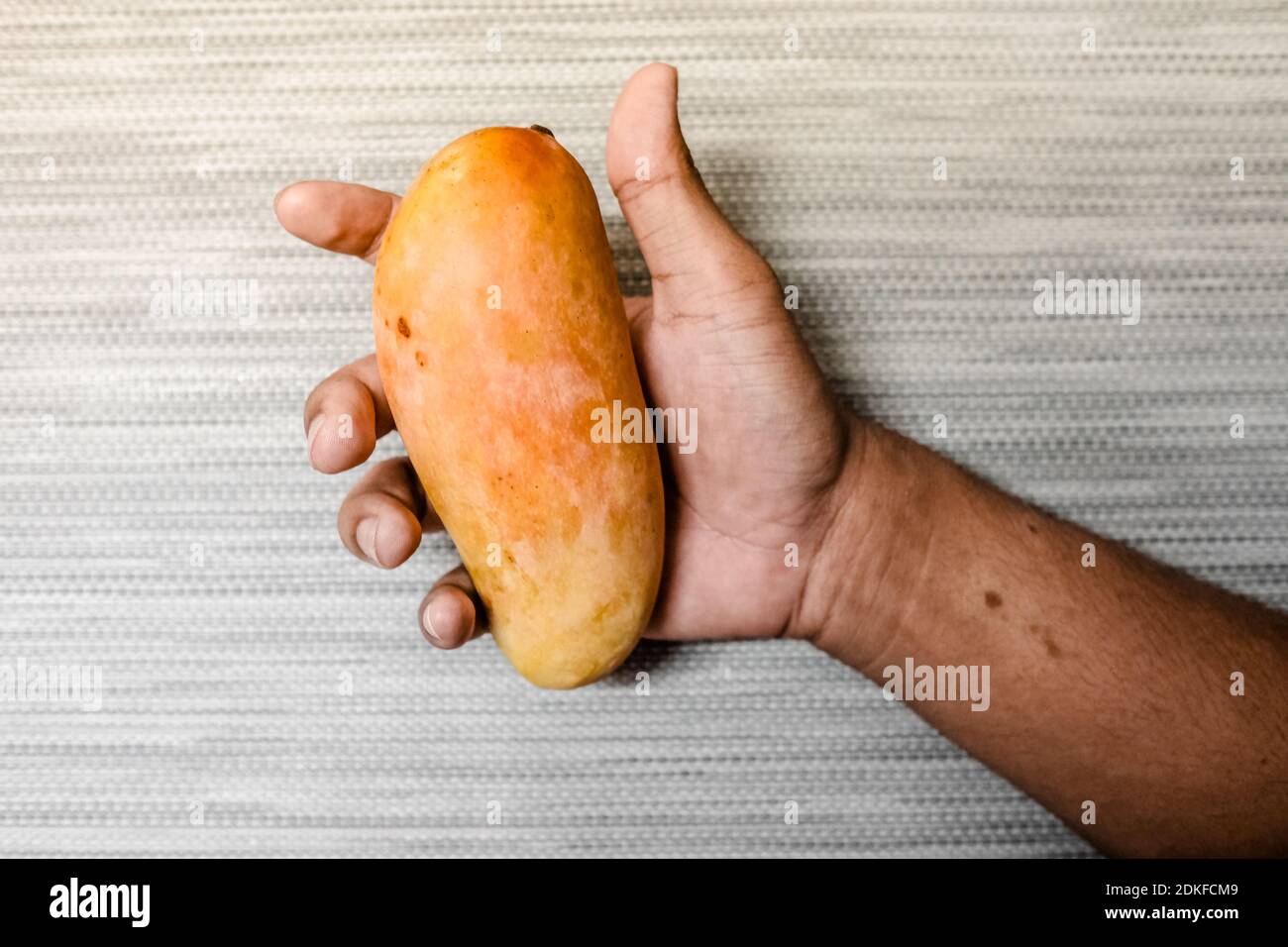 Hand man holding mango hi-res stock photography and images - Alamy