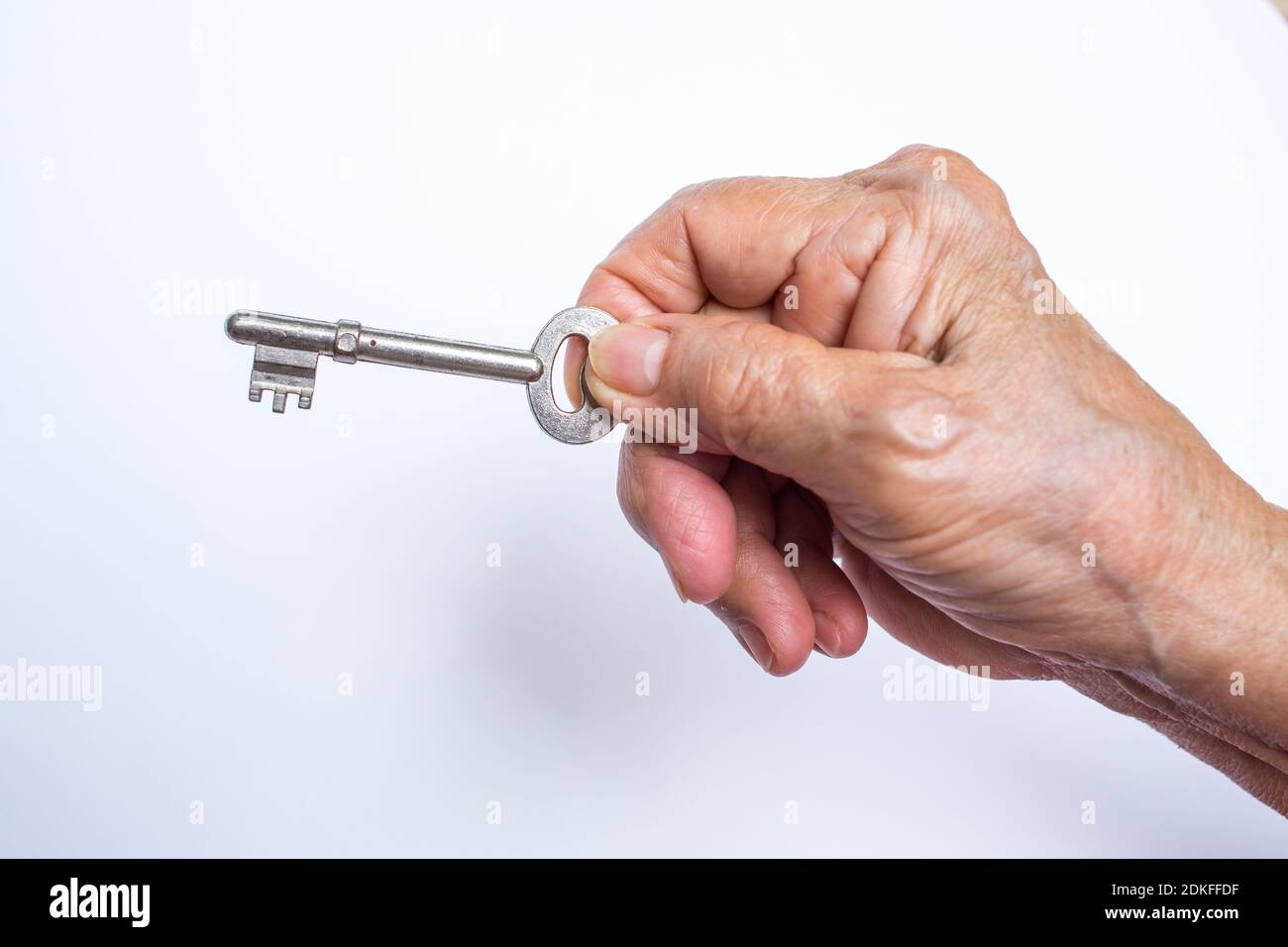 Senior woman's hand holding key isolated on white background Stock ...