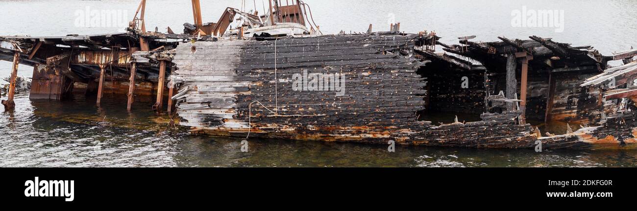 Fragment of rotting, abandoned ship on the shore, a symbol of decadence ...