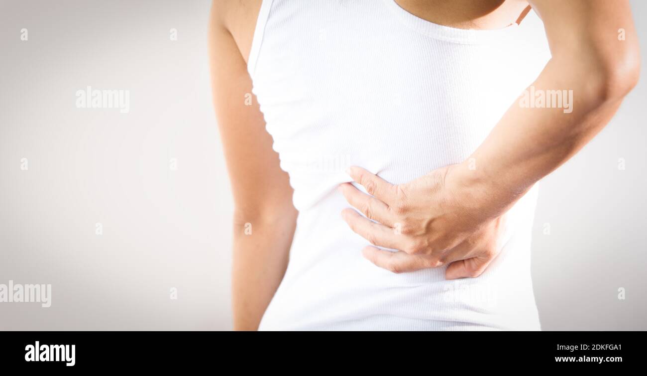 young woman pain at lower back, woman holding hand on lower back muscle ...