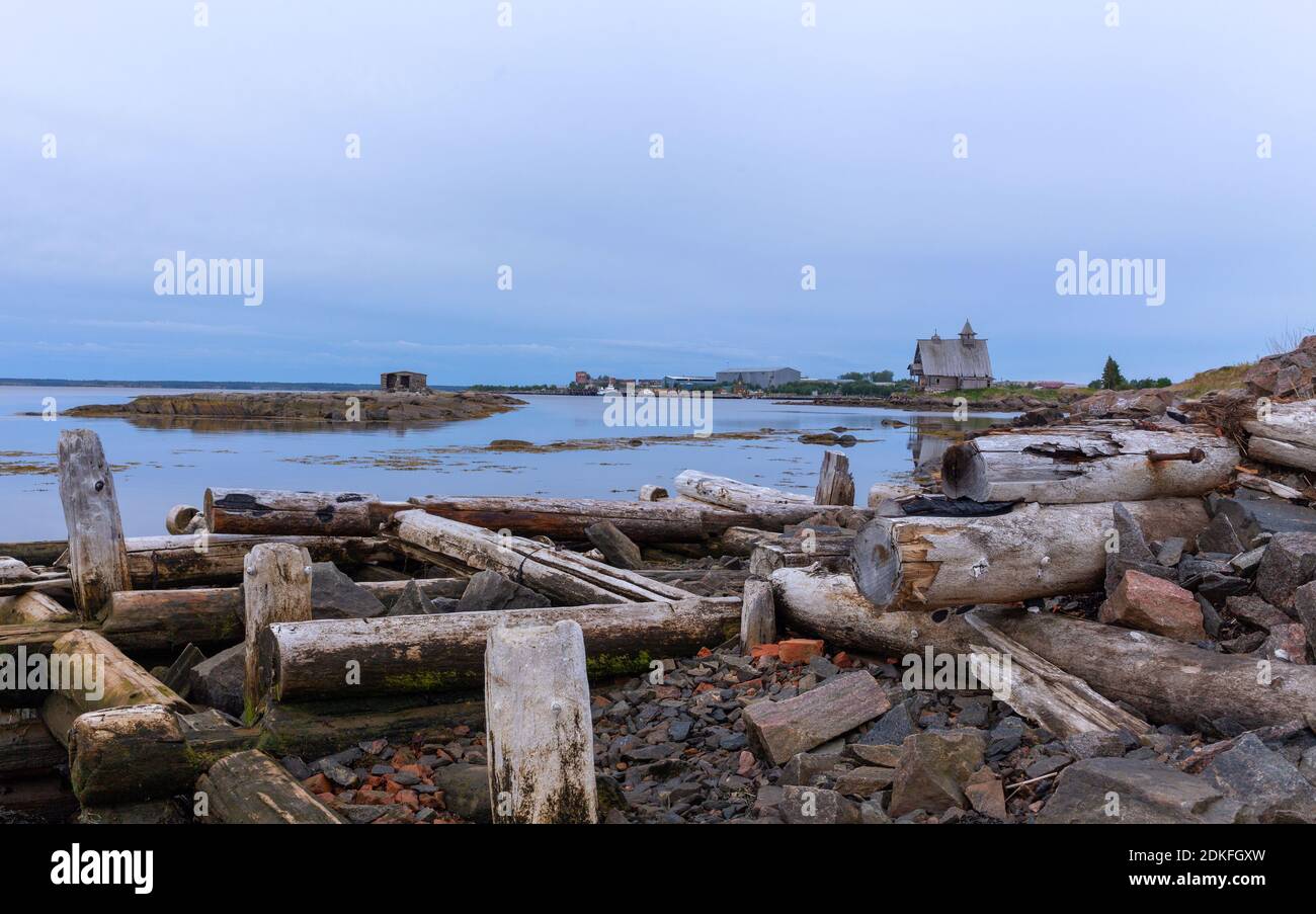Destroyed pier and an old log cabin on the shore, on a small deserted ...