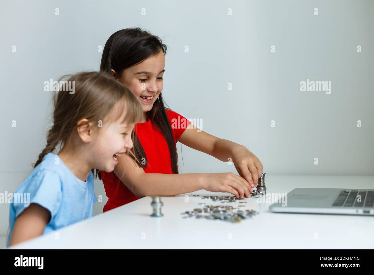 Two kids counting coins together Stock Photo - Alamy