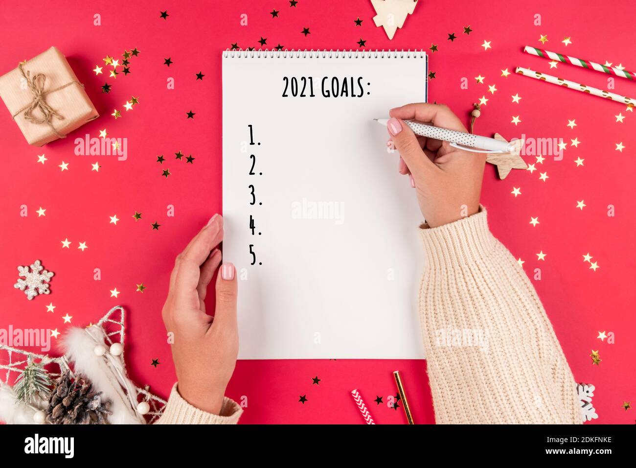 Girl writing goals for 2021 on a table with christmas decorations Stock ...