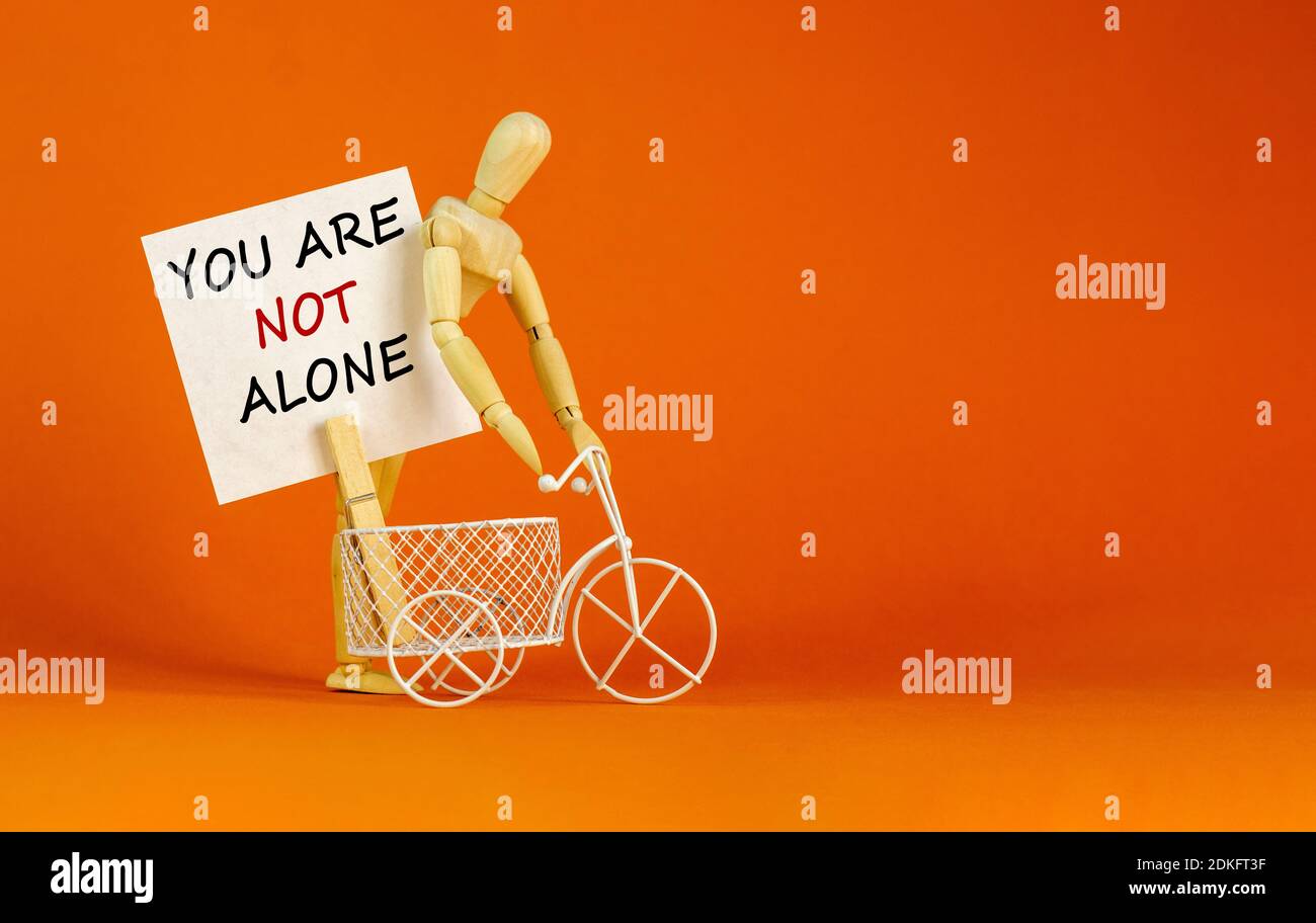 You are not alone symbol. Clothespin with white paper. Words 'you are ...