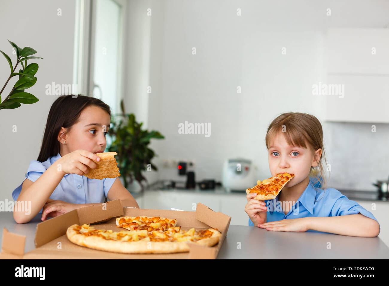 Two happy little child girl friends eating pizza slices Stock Photo - Alamy
