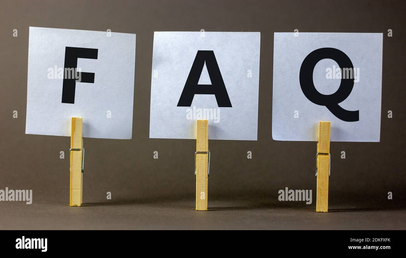 FAQ symbol. Wooden clothespins with white sheets of paper with word ...
