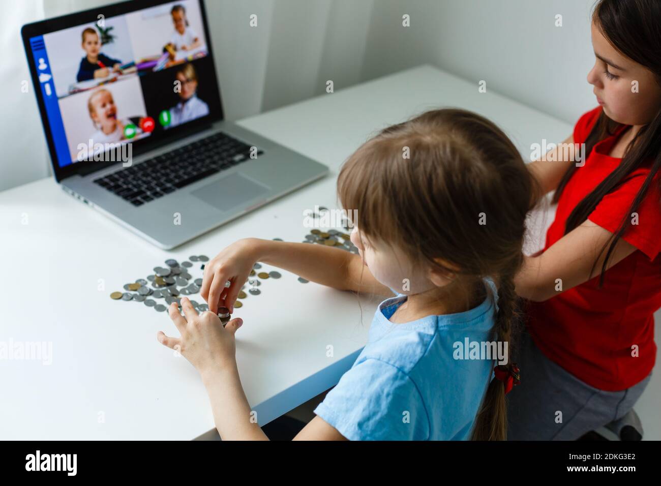 Two kids counting coins together Stock Photo - Alamy