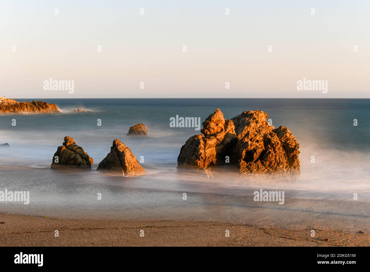 Stunning long-exposure view of smooth waves crashing into rock ...