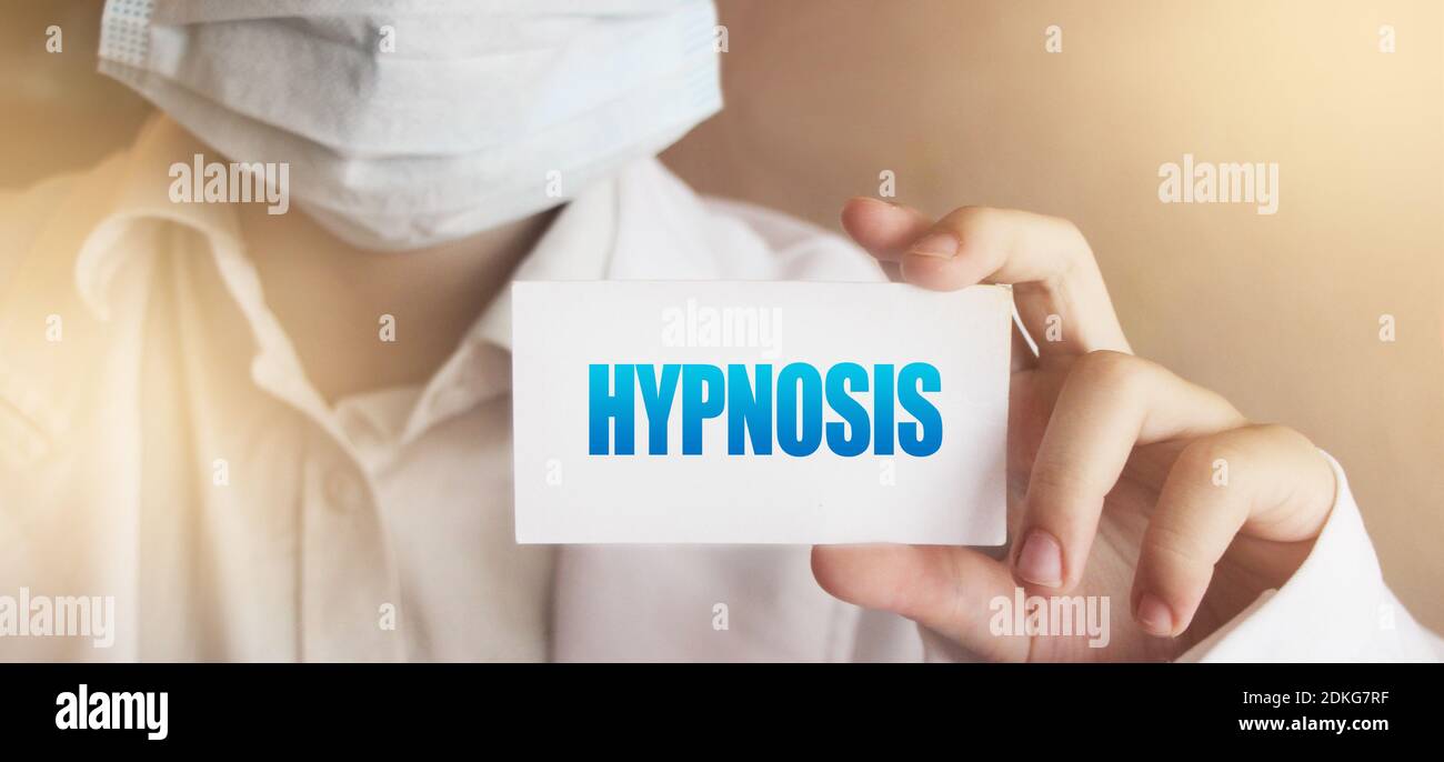 Hypnosis word written on a card in doctor's hand. Alternative therapy ...