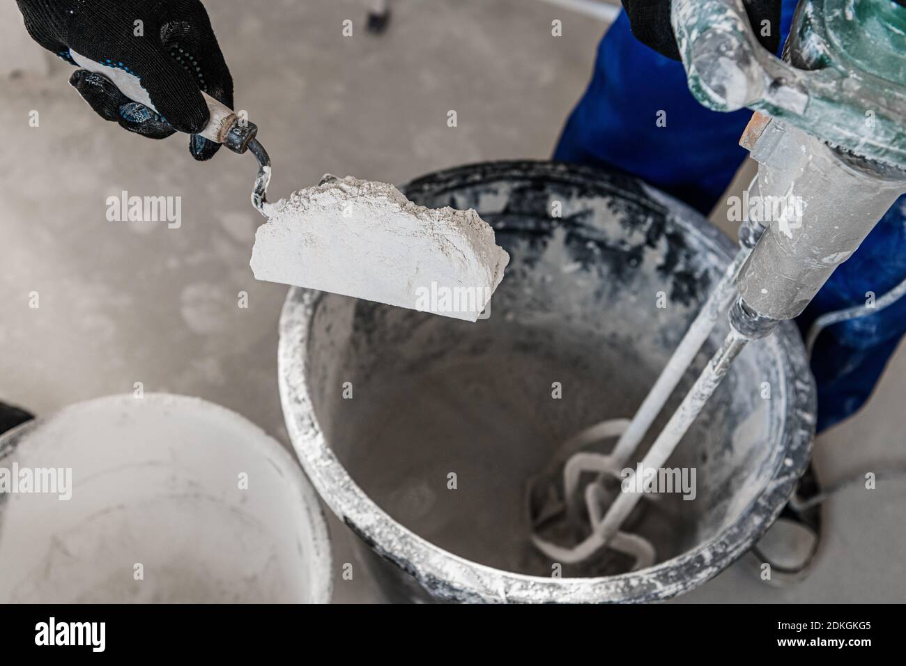The foreman puts cement into the bucket. He uses a trowel Stock Photo ...