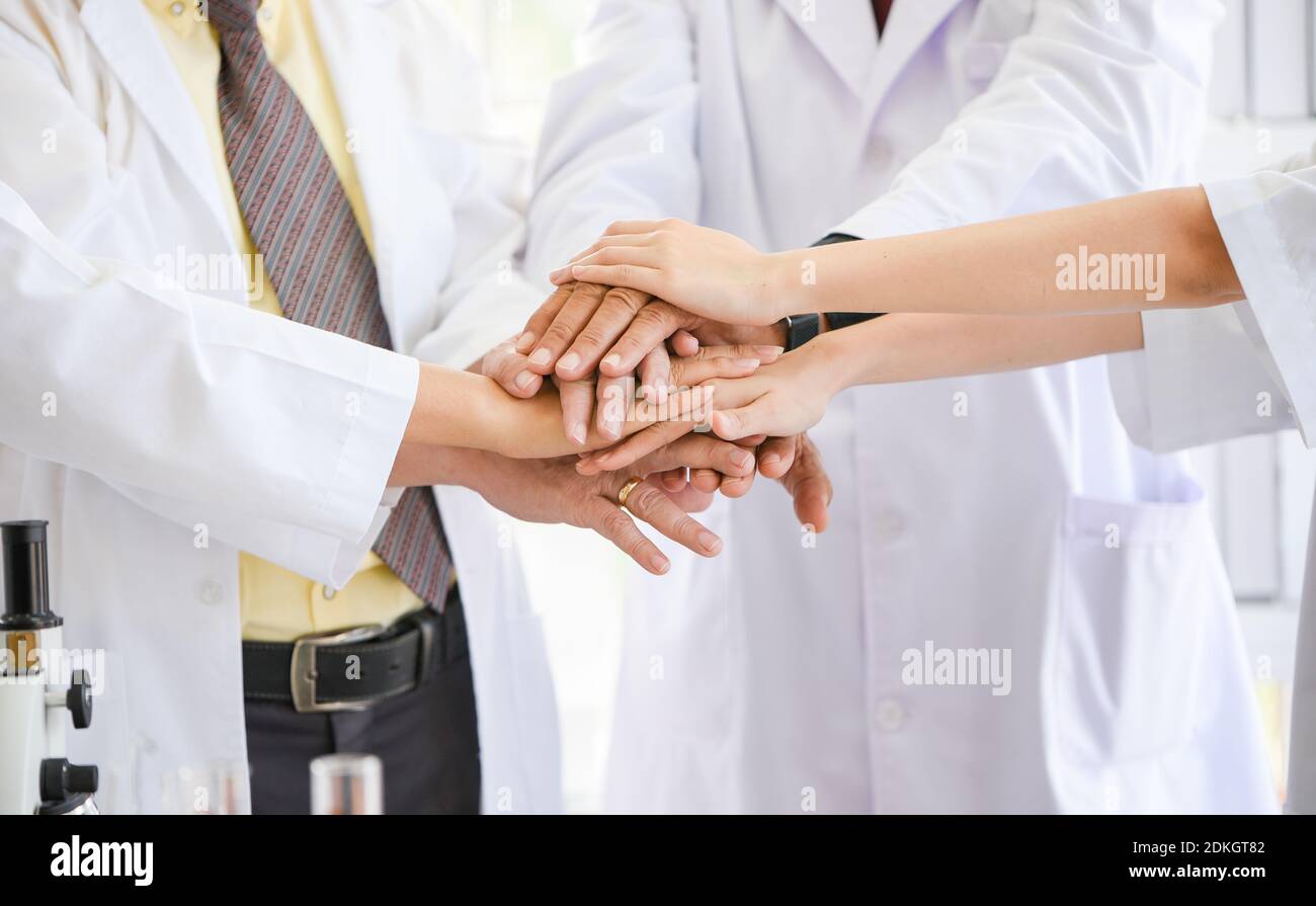 Science laboratory teamwork stacking hands Stock Photo - Alamy