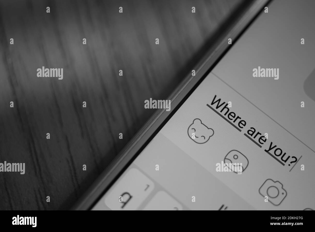 Smartphone on the table with message on a screen Where are you. BW ...