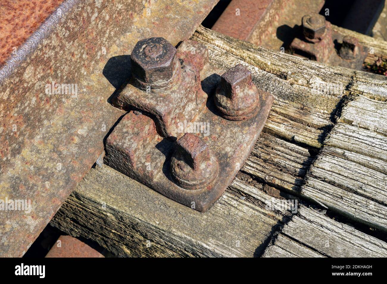 Old wooden railway sleeper, rusty hexagon nut and iron screws Stock ...