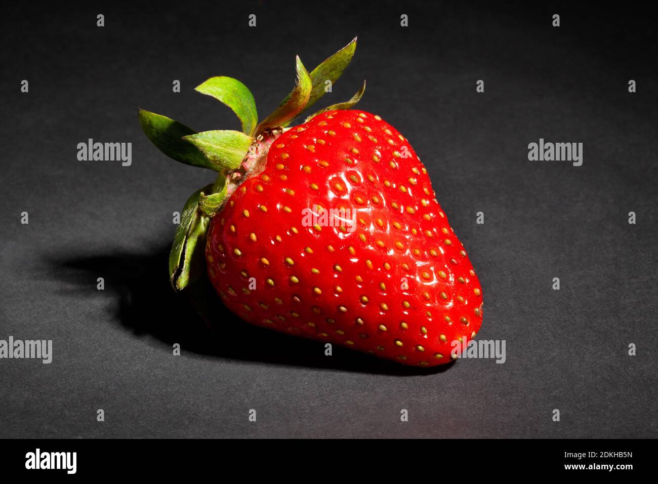 one strawberry on black background Stock Photo - Alamy