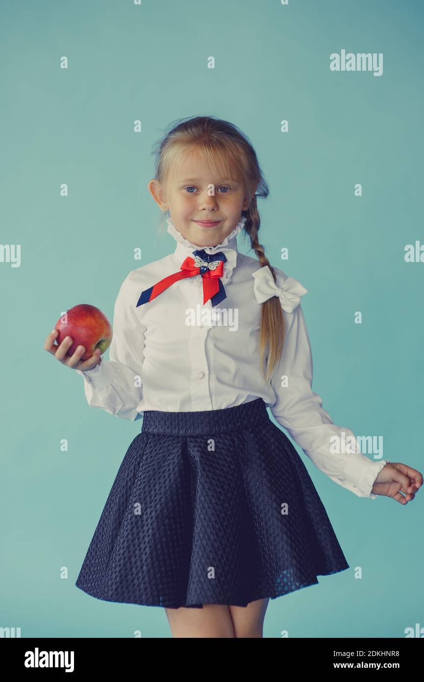 Schoolgirl on blue background. Girl in a school skirt and blouse on a ...