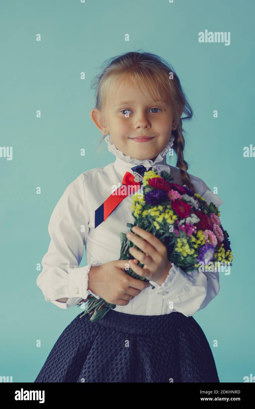 Schoolgirl on blue background. Girl in a school skirt and blouse on a ...