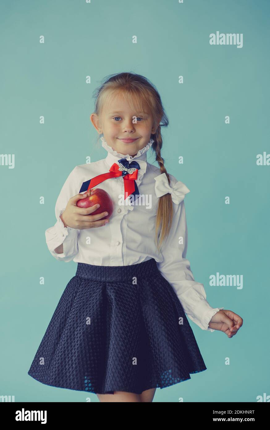 Schoolgirl on blue background. Girl in a school skirt and blouse on a ...